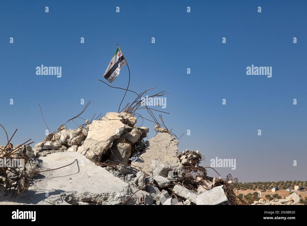 A Free Syrian Army flag hanging from the rebar of a building destroyed ...