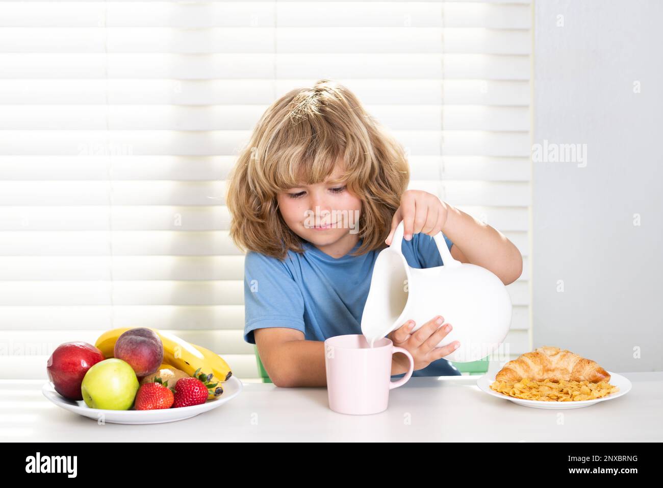 Child eating meal. Kid pouring whole cows milk. Healthy nutrition for ...