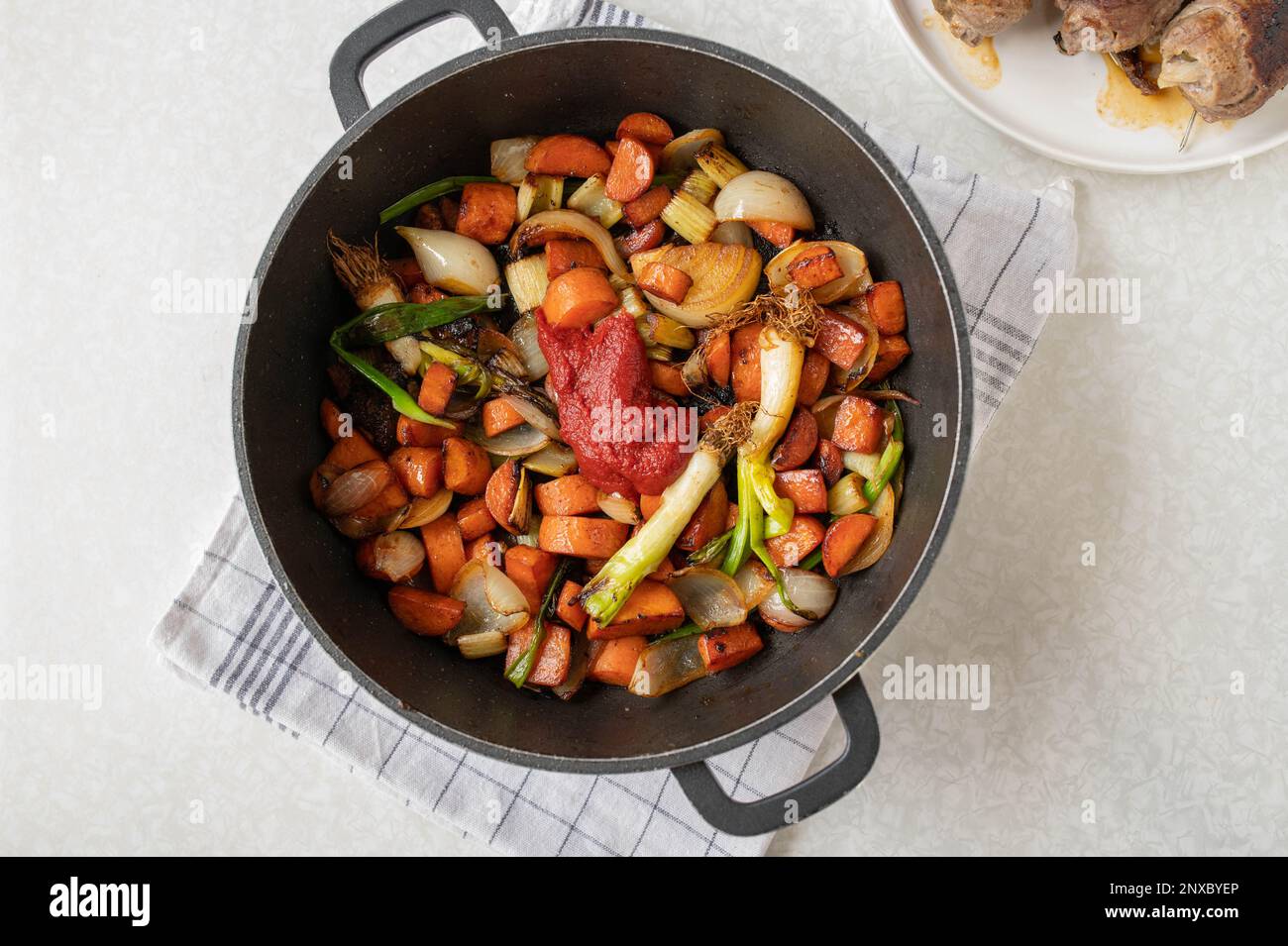 Roasted root vegetables or mirepoix with tomato paste in a roasting pan ...