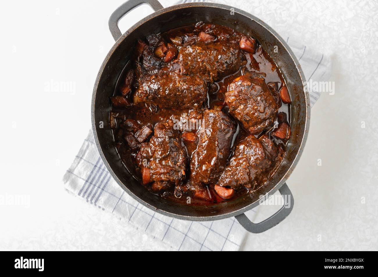 Beef roulades with gravy and roasted vegetables in a roasting pan ...