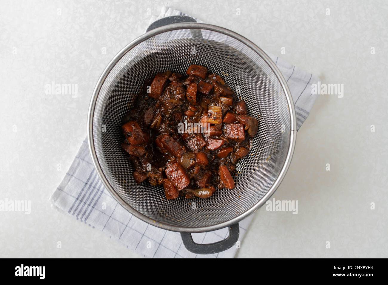 Sieving mirepoix or roasted and cooked root vegetables for making brown ...