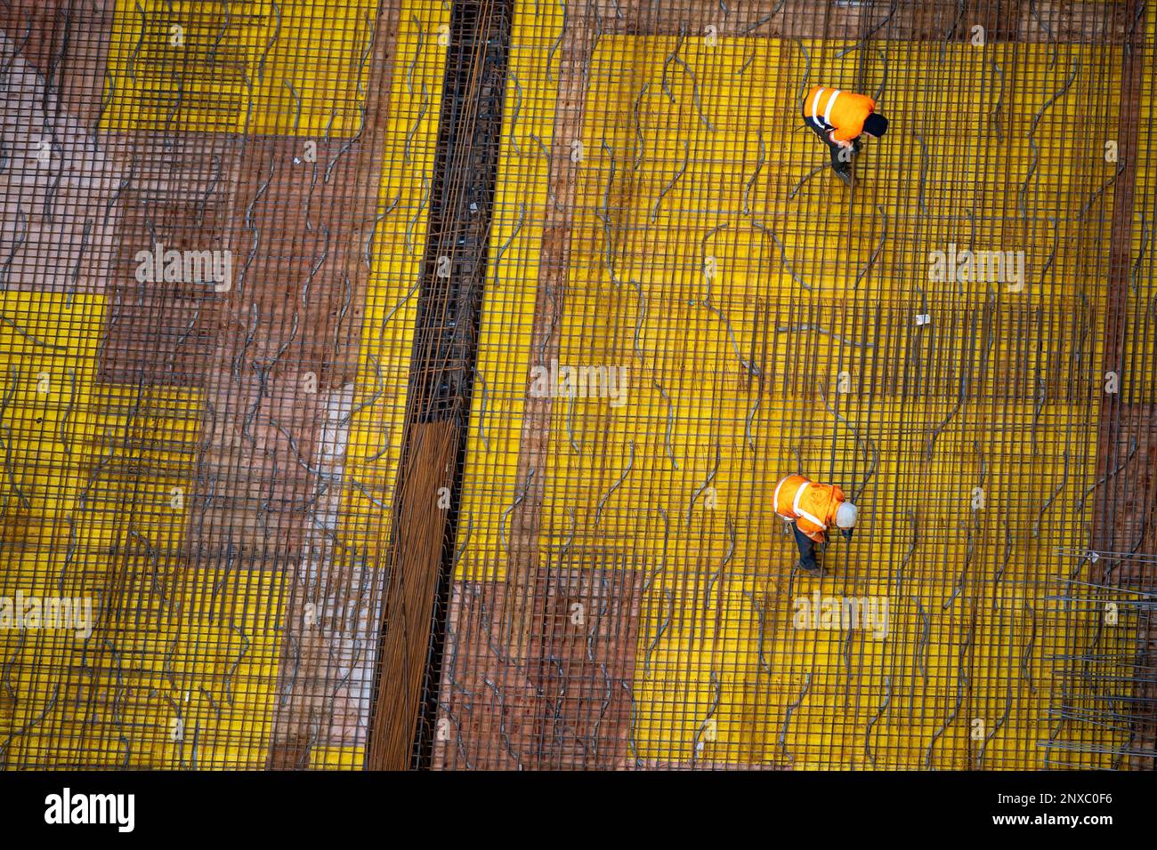 Top view of workers preparing a concrete foundation plate at a ...