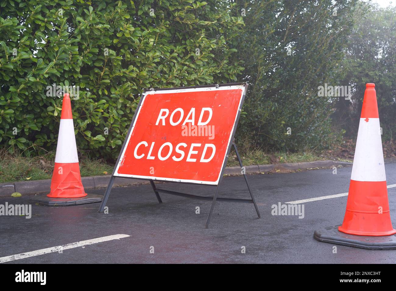 Road closed sign with traffic cones blocking a UK road, set in the ...
