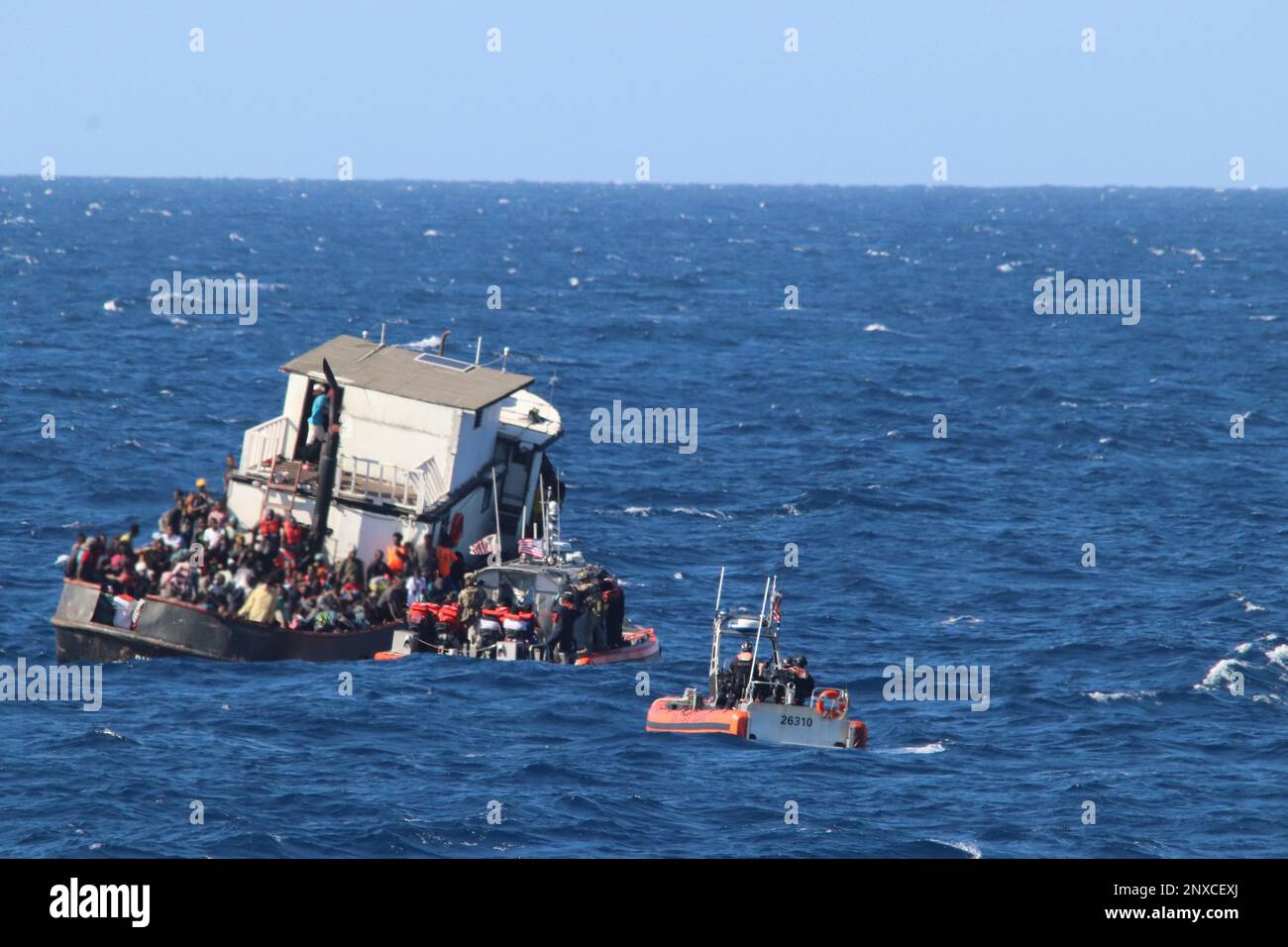 A Coast Guard small boat converges on the position of an overloaded 80 ...