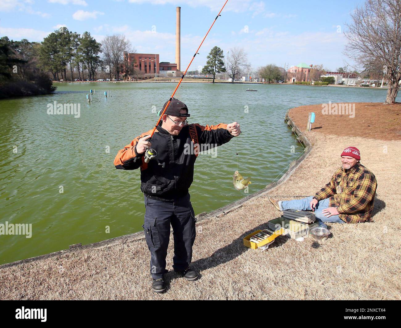 Chris Bowers, left, reacts after reeling in a bluegill Thursday while ...