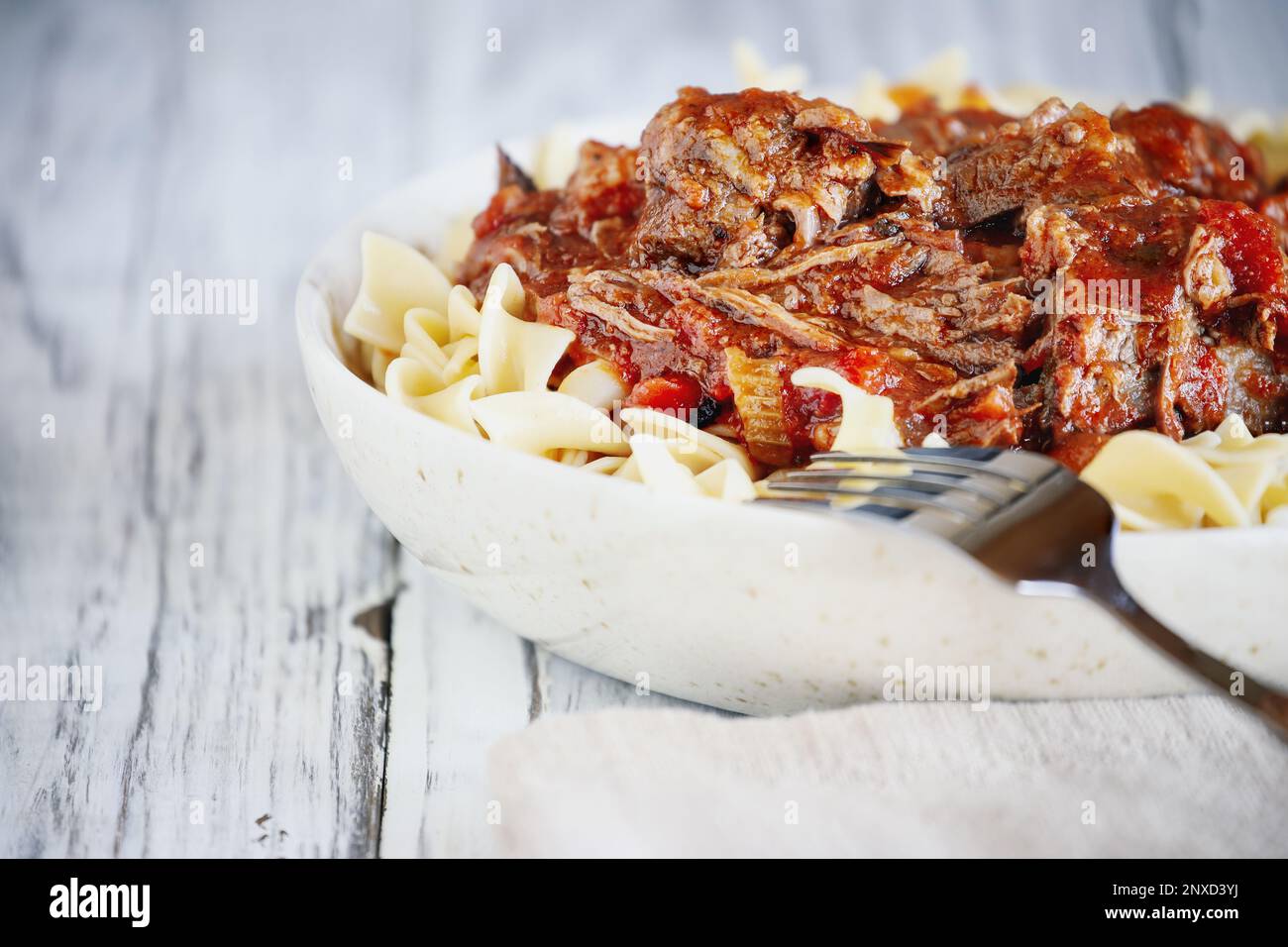 Hearty bowl of fresh homemade beef ragu over cooked egg noodle pasta ...