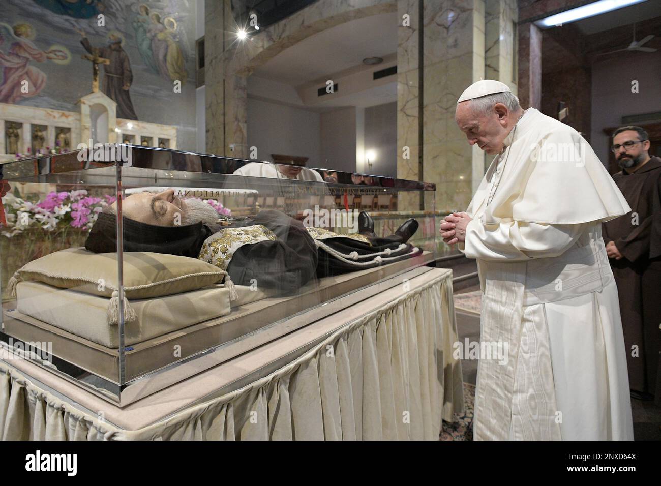 Pope Francis prays before a glass display case holding St. Padre Pio ...