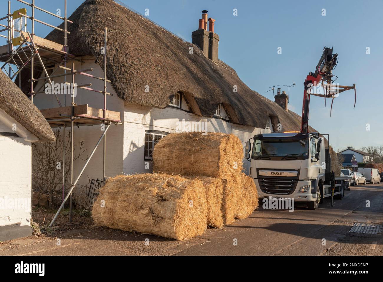 Hampshire, England, UK. 2023. Thatching straw in rolls being off loaded ...