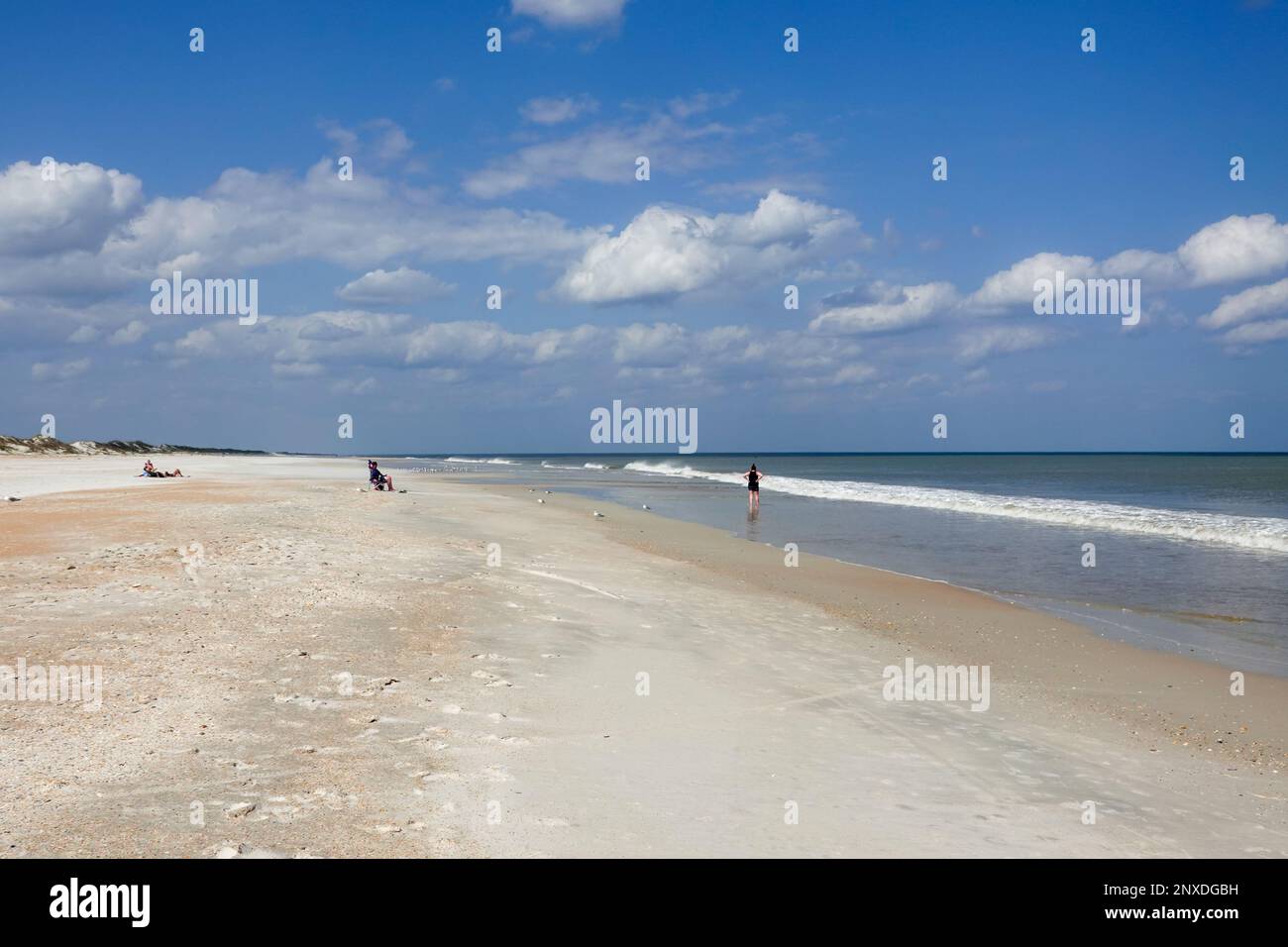 Four people enjoying almost empty beach on a nice day in February ...
