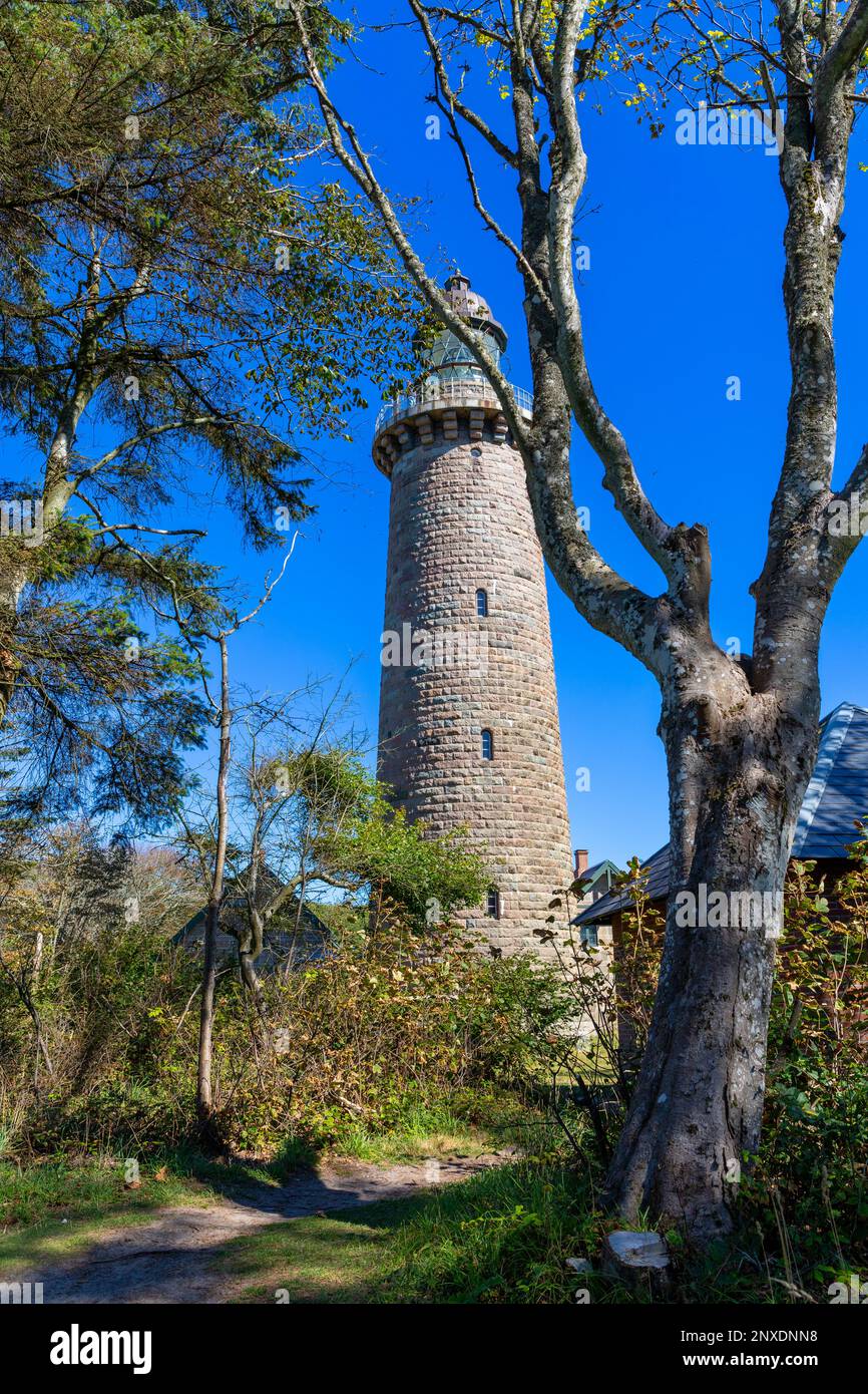 Lodbjerg Fyr from afar between trees with blue sky, Denmark Stock Photo ...