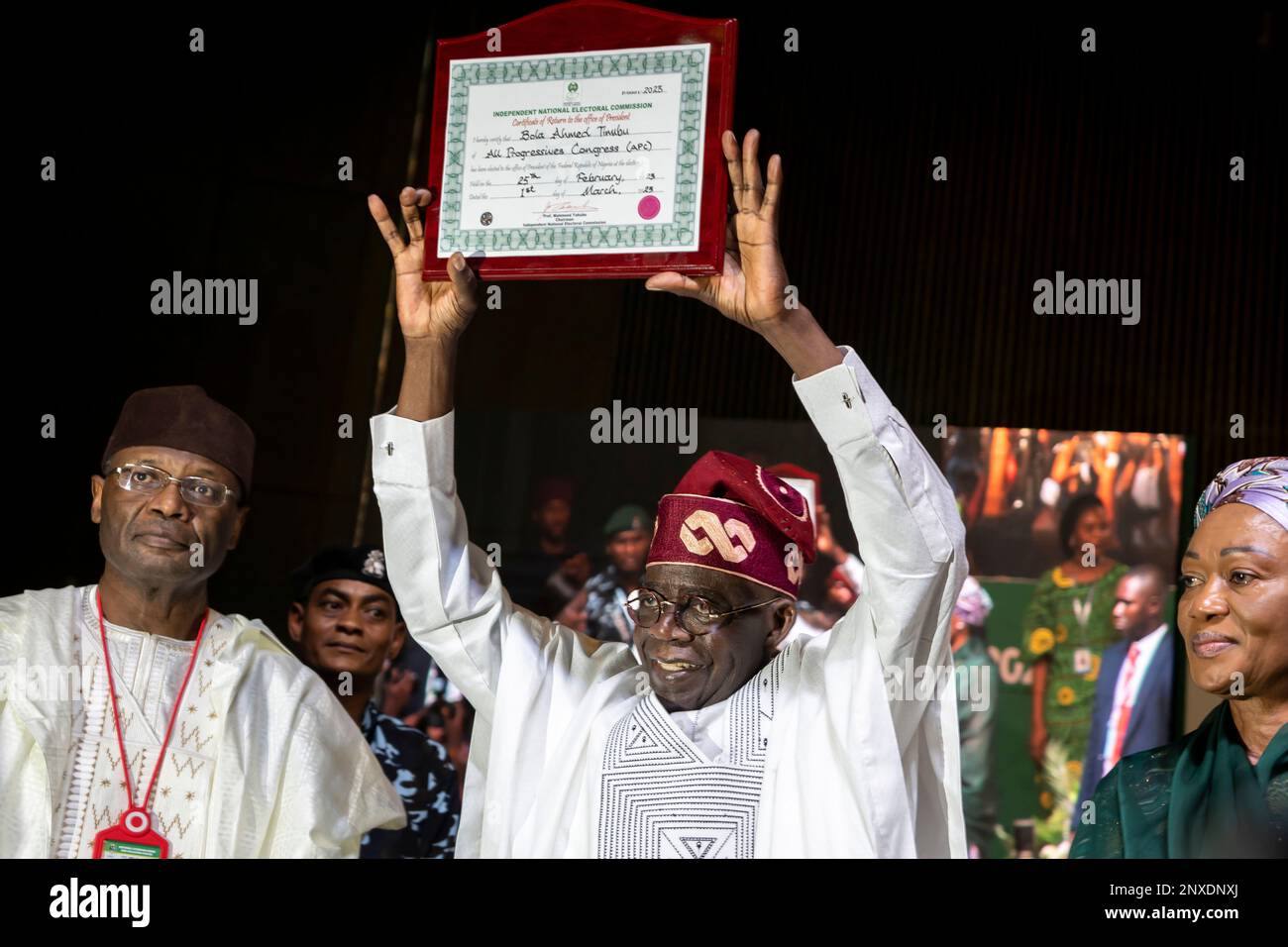 President-Elect Bola Tinubu, center, displays his certificate, accompanied by his wife Oluremi ...