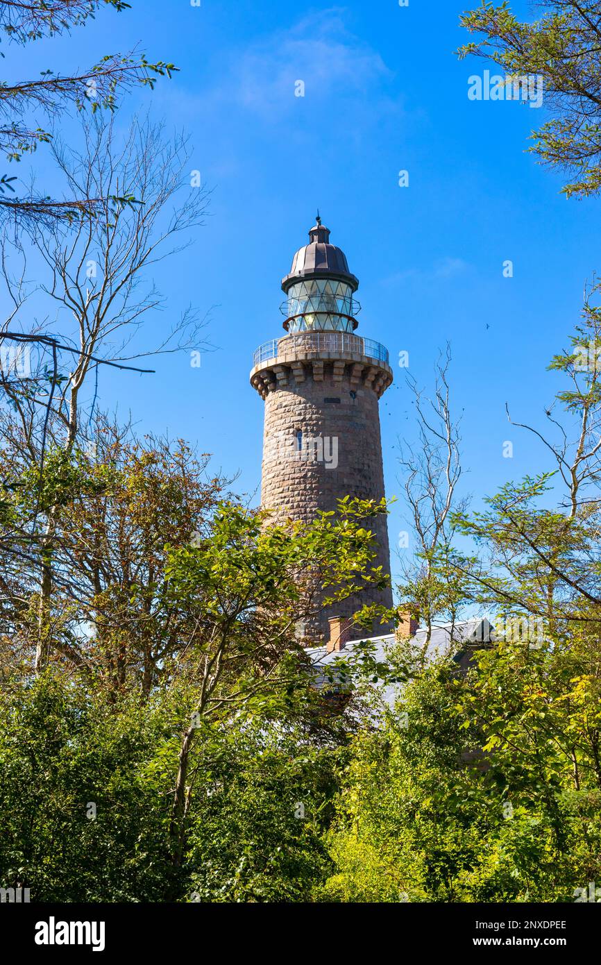 Lodbjerg Fyr from afar between trees with blue sky, Denmark Stock Photo ...
