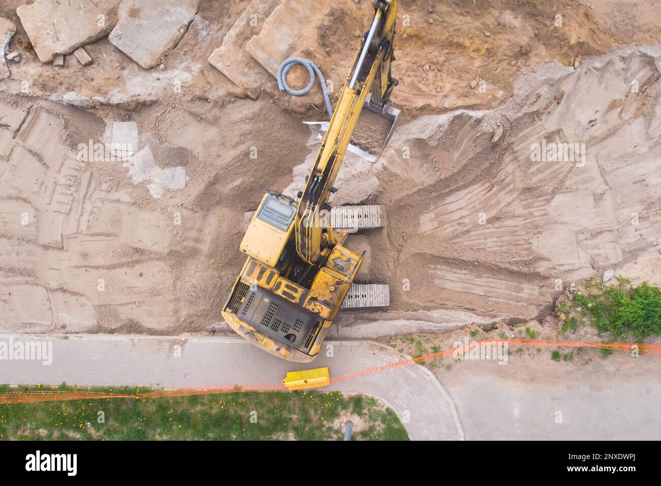 Yellow heavy excavator excavating sand and working during road works ...