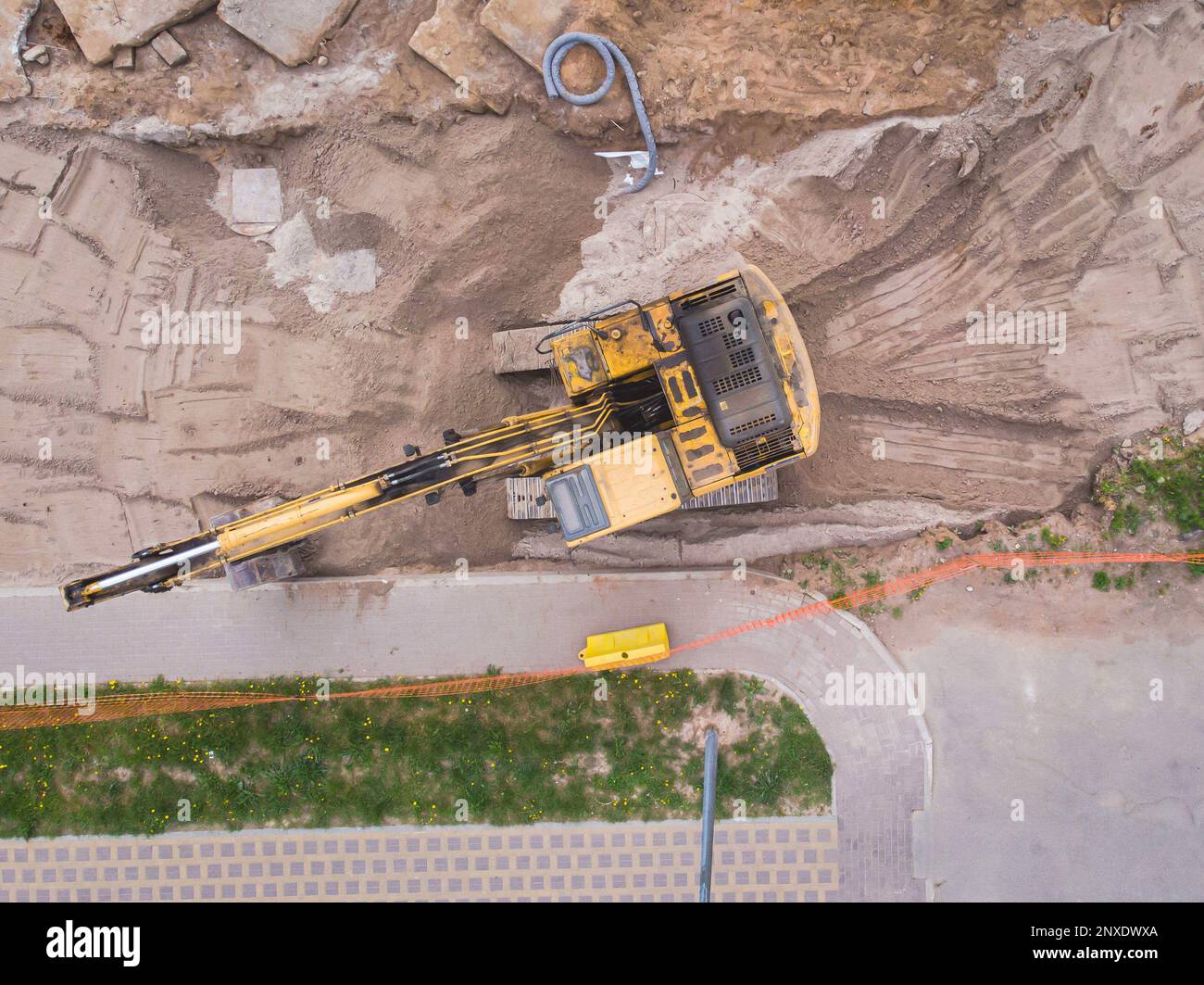 Yellow heavy excavator excavating sand and working during road works ...
