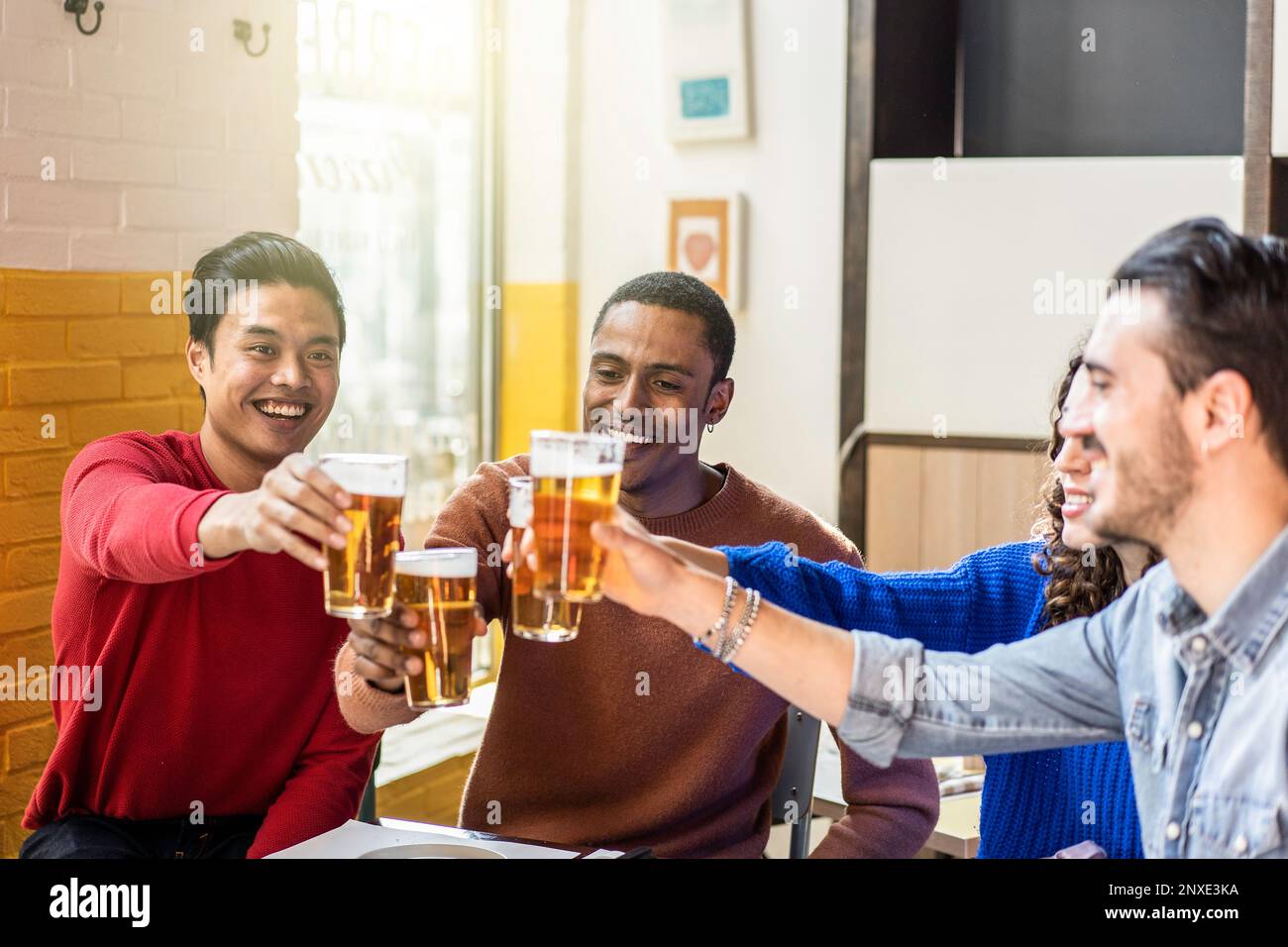 Happy friends drinking beer at pub bar - Multiracial lifestyle concept ...