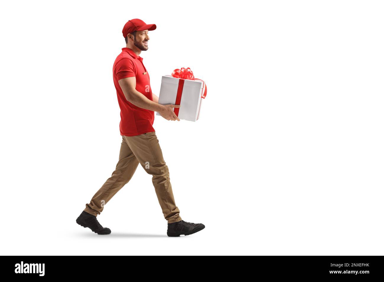Full length profile shot of a delivery worker carrying a present box ...