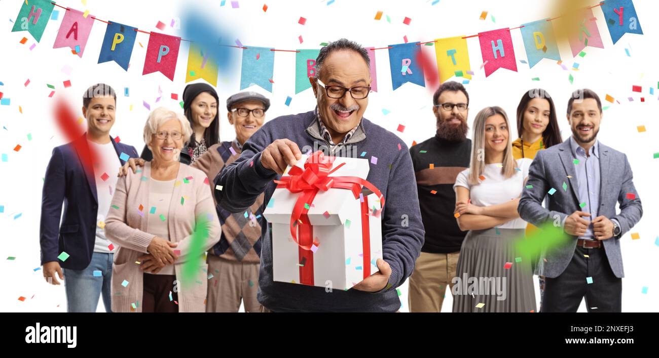 Happy mature man opening a gift box and people gathered at a ...