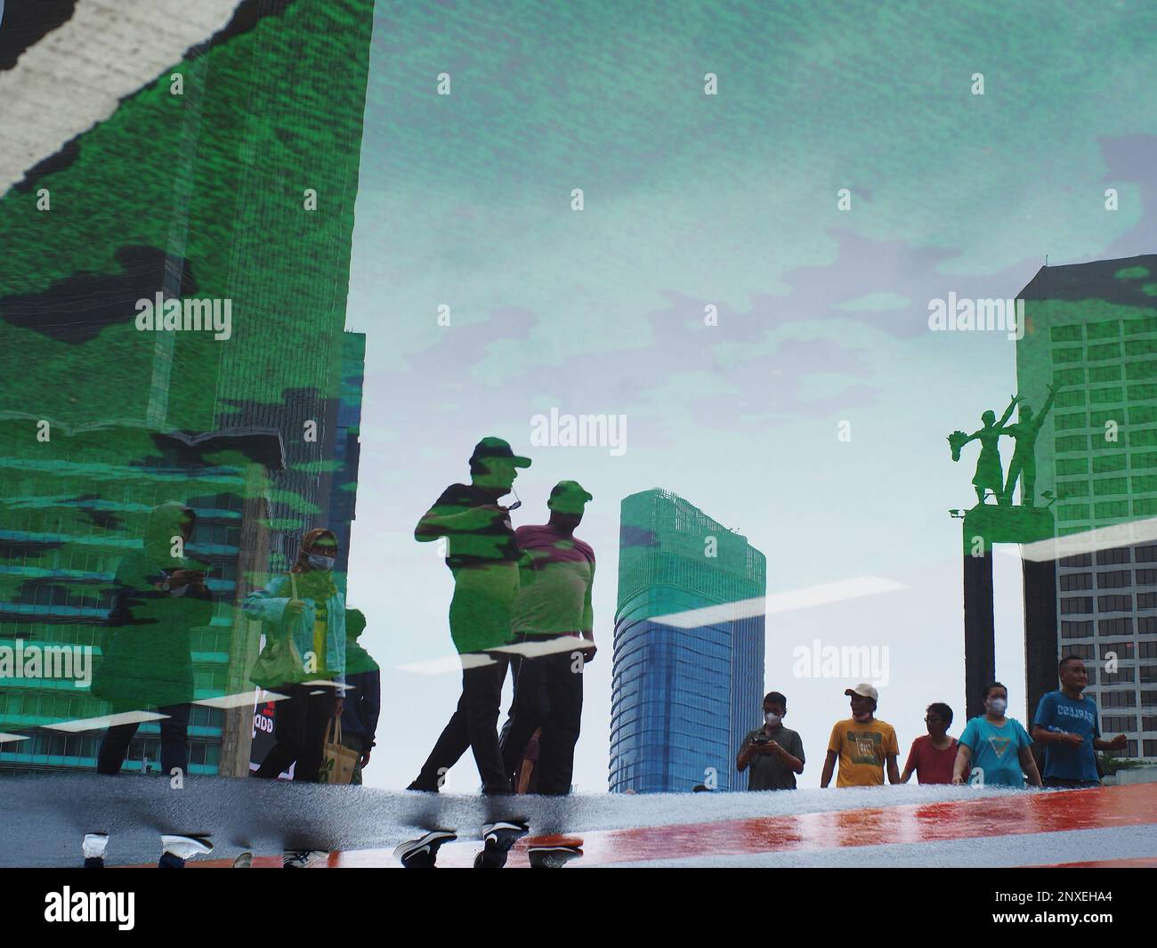 People is seen on reflection in front of "Welcome Statue" as symbol ...