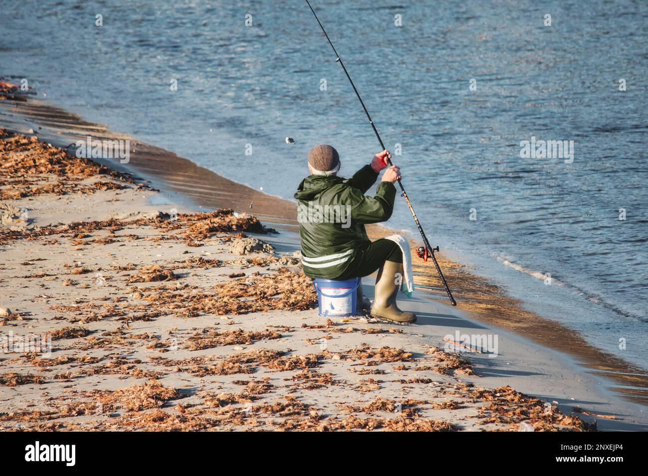 Man sitting on bucket fishing hi-res stock photography and images - Alamy