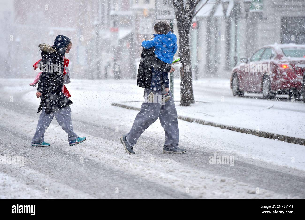 Pedestrians cross Broad Street in Bethlehem, Pa., while snow begins to ...