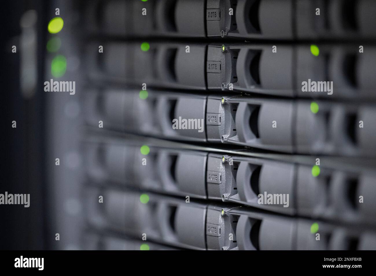depth of field of gray disk slots of an it network attached storage device with green LEDs Stock ...