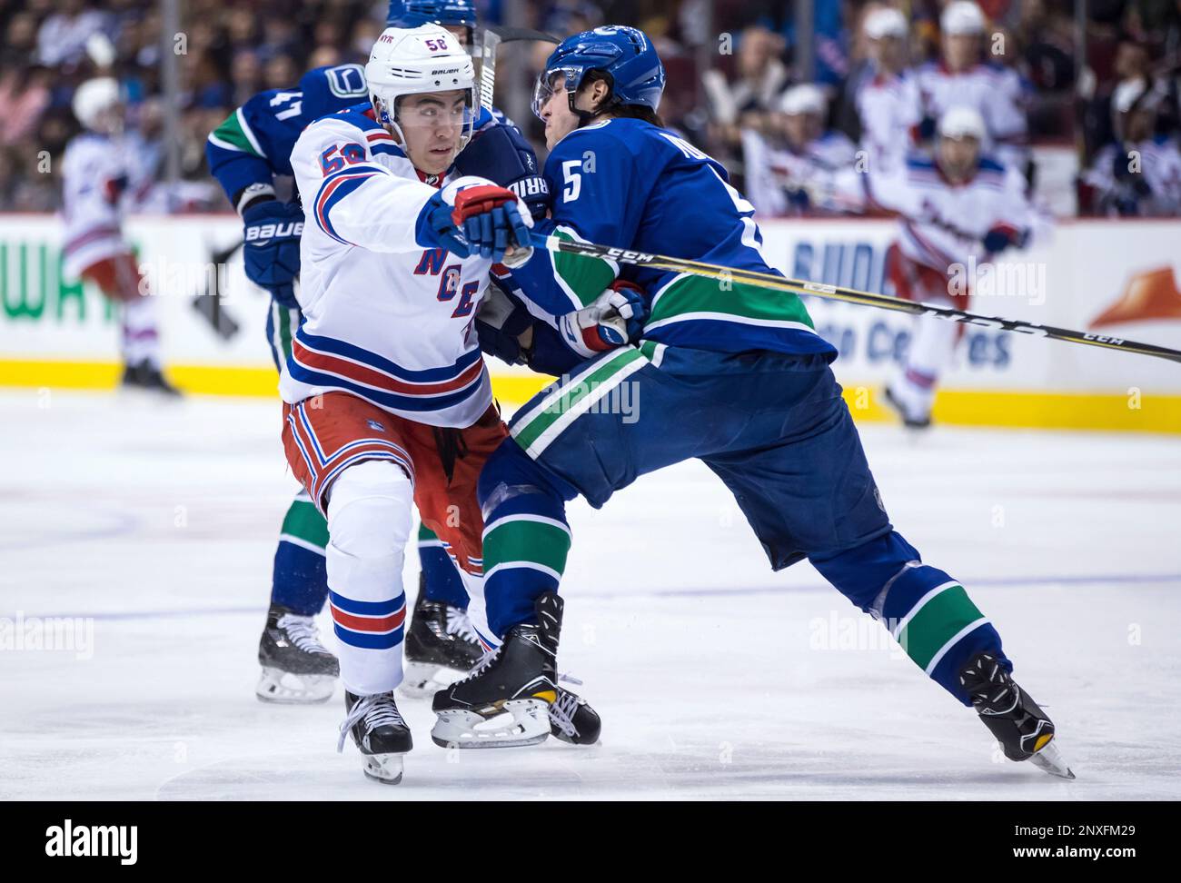Vancouver Canucks' Derrick Pouliot, right, checks New York Rangers ...