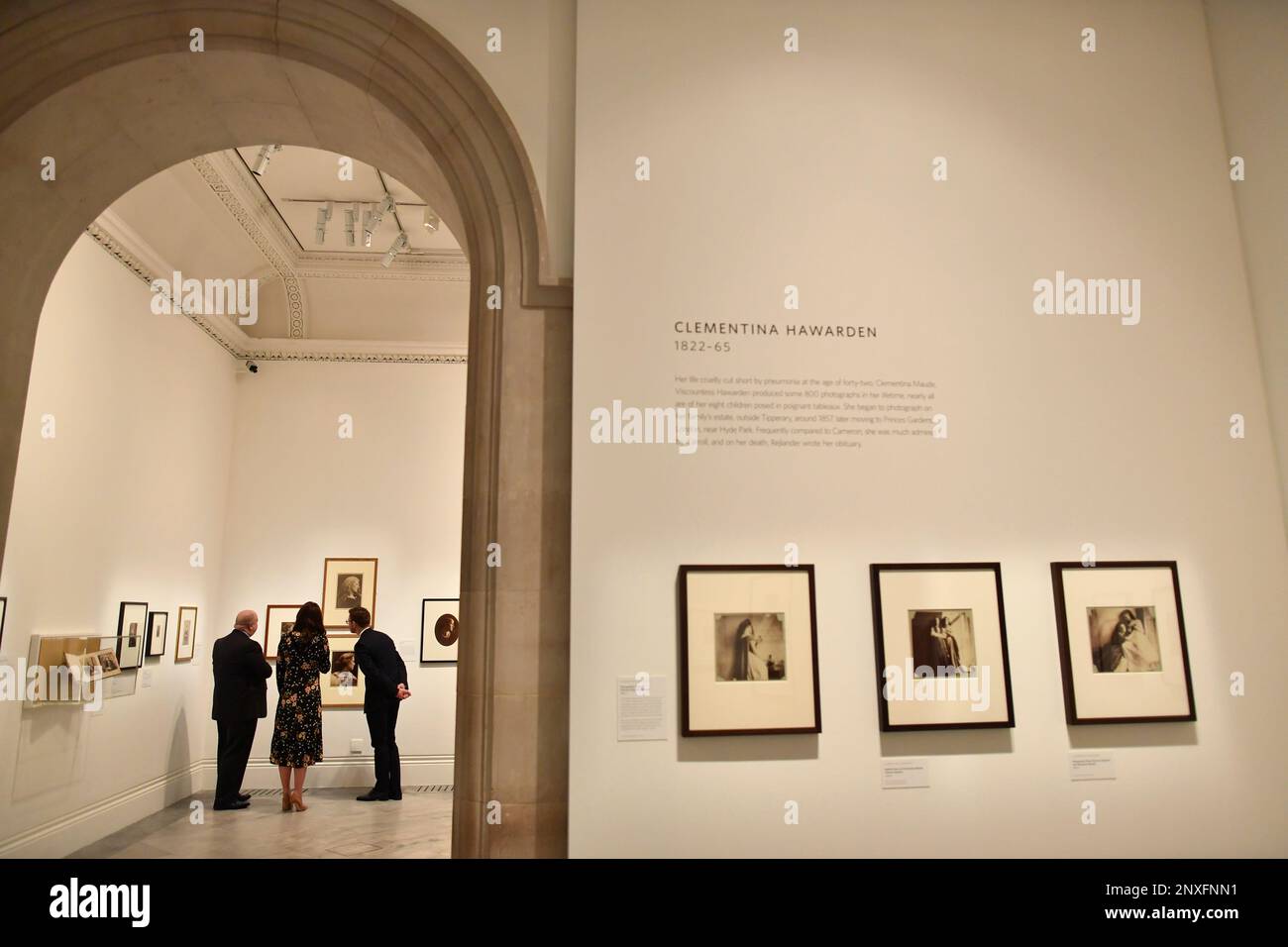 Britain's Kate, Duchess of Cambridge gestures, centre, is guided around the exhibition ...