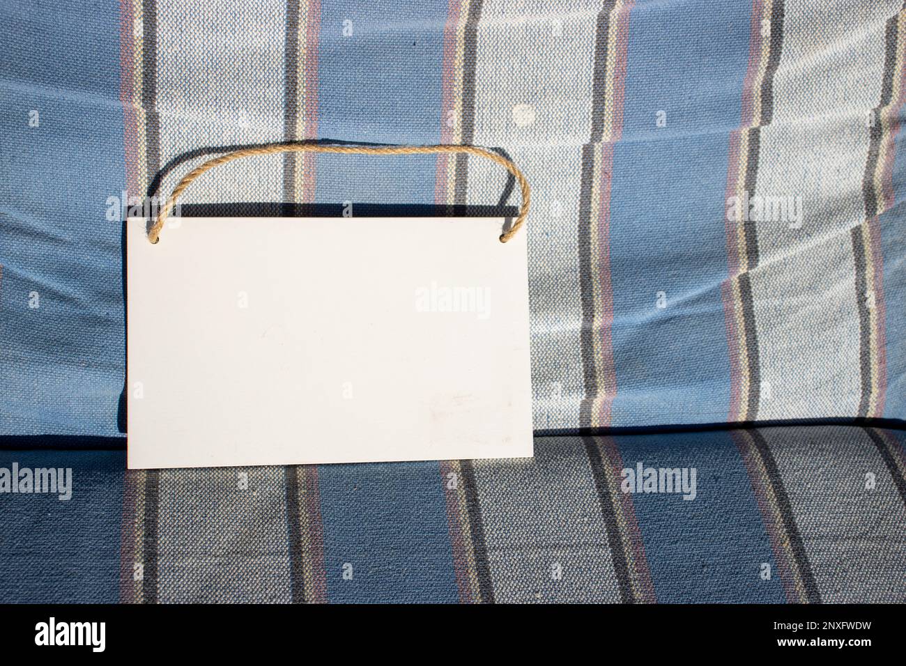 blue and white striped material and a white hanging picture sign with ...