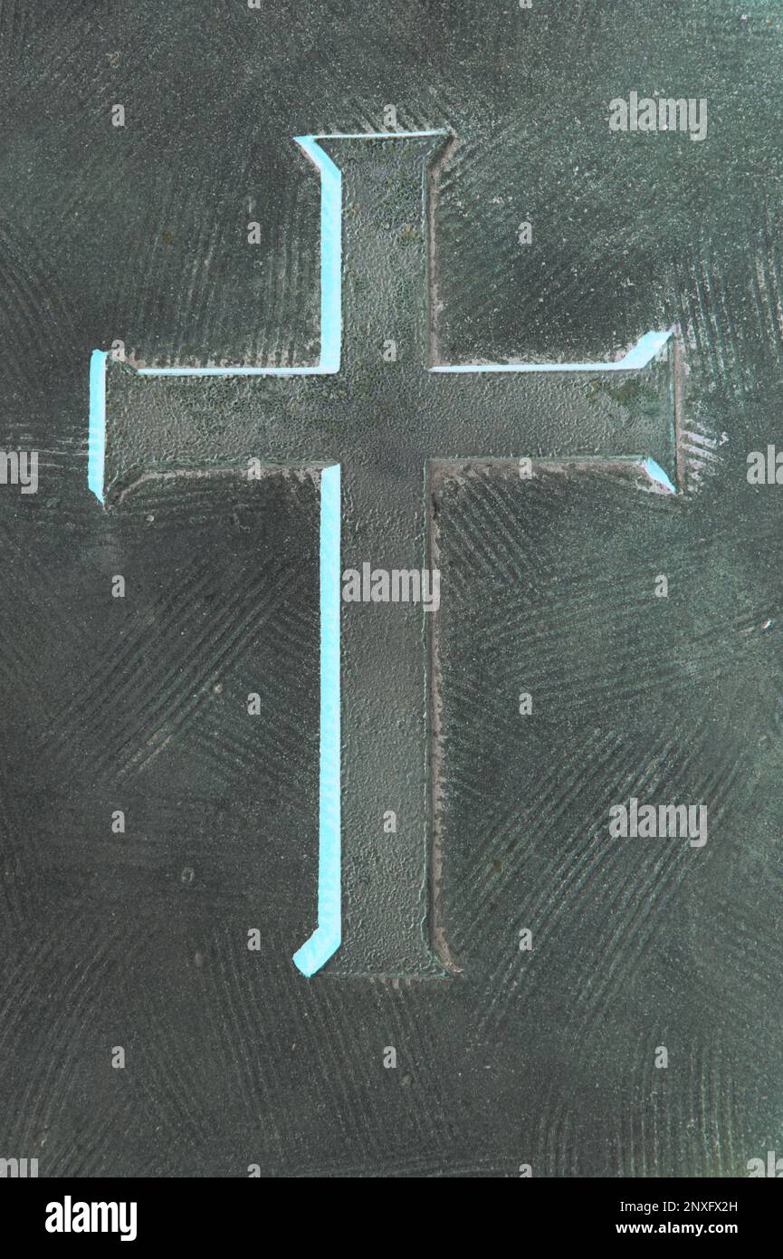 A simple typical cross embossed on a copper metal wall in a color film ...