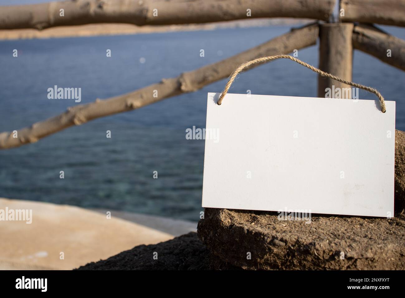 left overlooking the blue sea a white hanging picture sign with empty ...