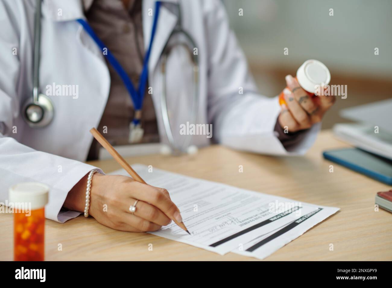 General practitioner writing out prescription for patient Stock Photo ...
