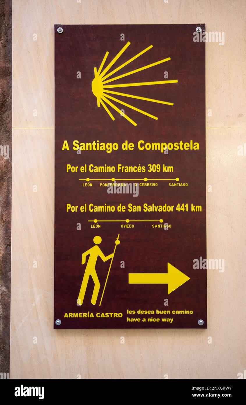 A brown sign with the Camino de Santiago symbol, a yellow scallop shell ...
