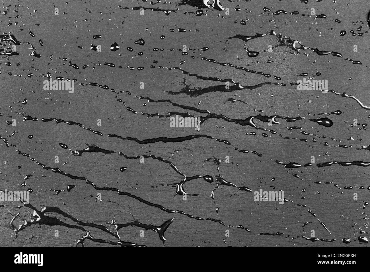 Water drops on dark flat stone surface of basalt or granite background ...