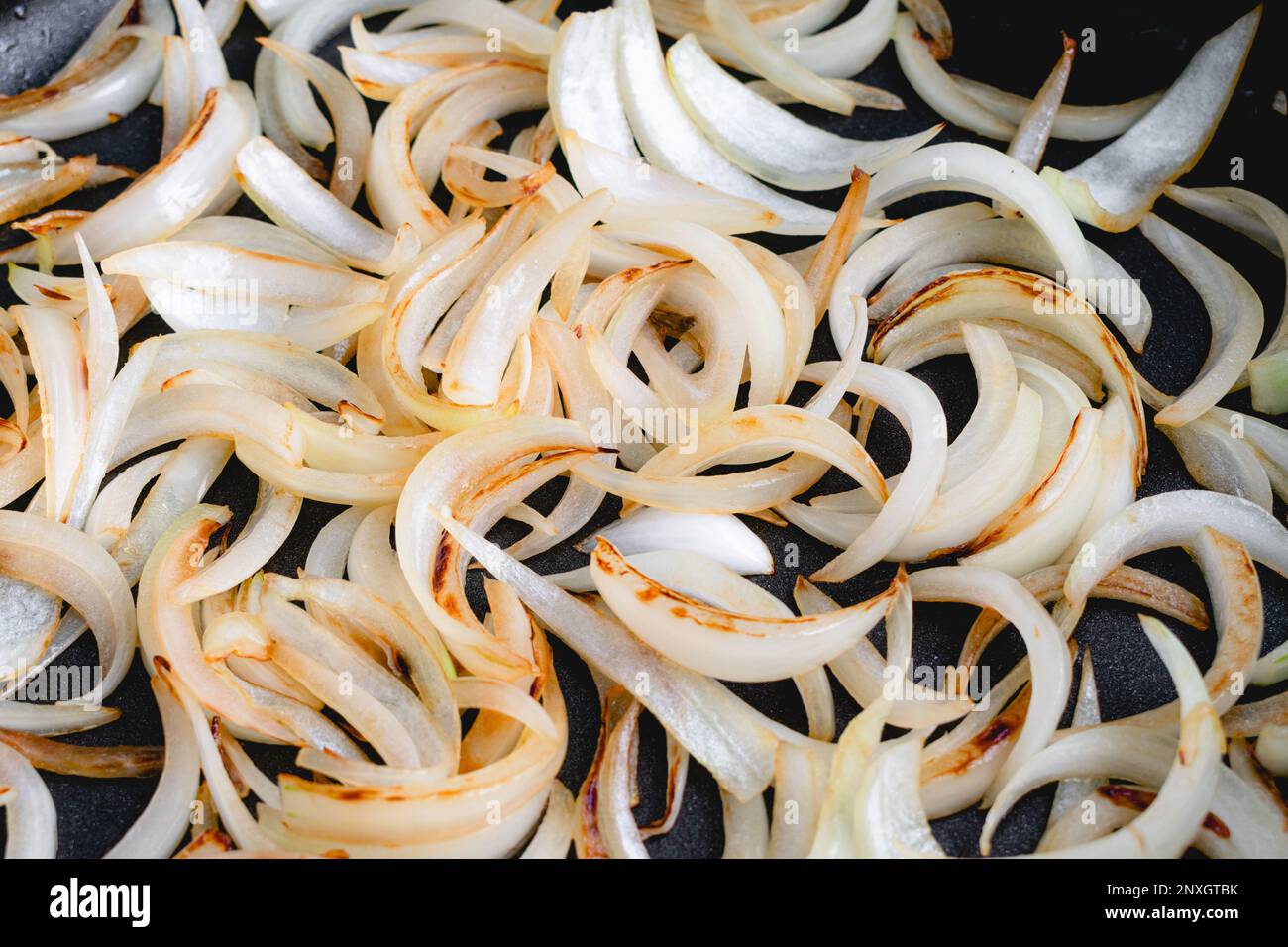 Close Up View of Sliced Onions Browned in a Skillet: Slices of sweet ...