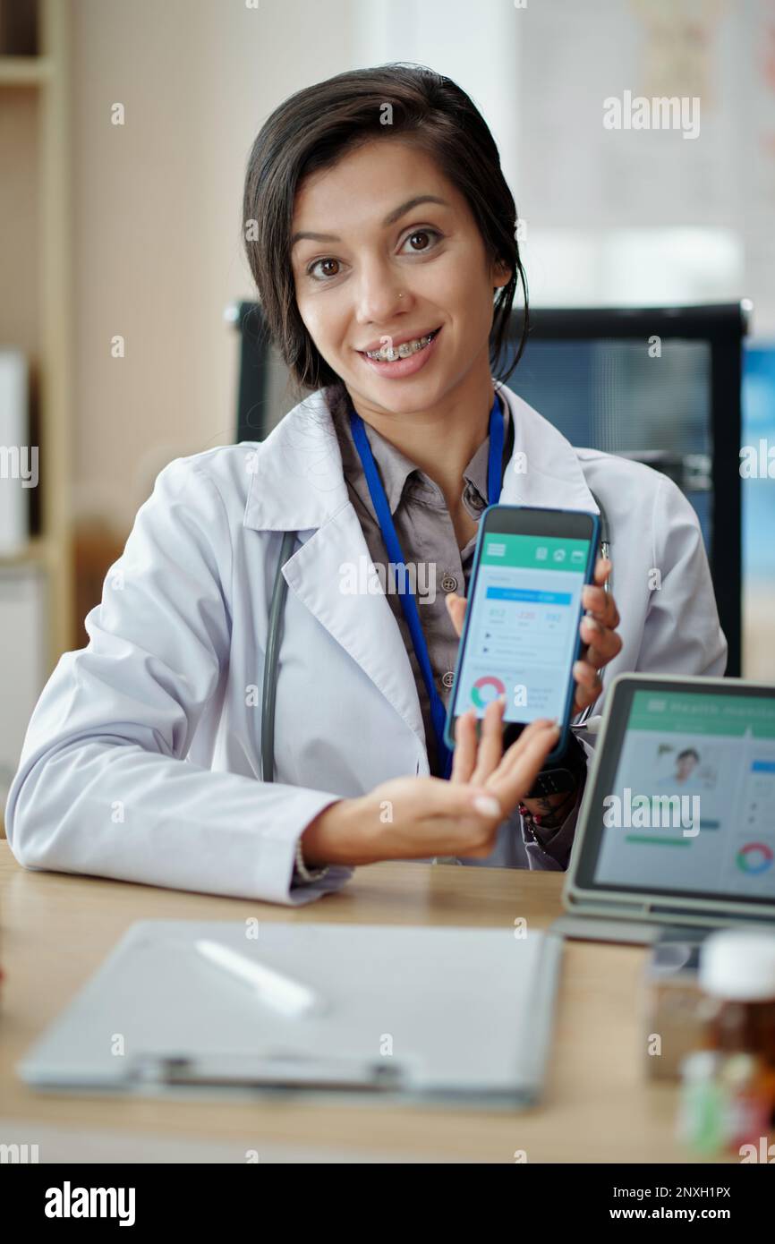 Cheerful doctor recommending new healthcare application Stock Photo - Alamy
