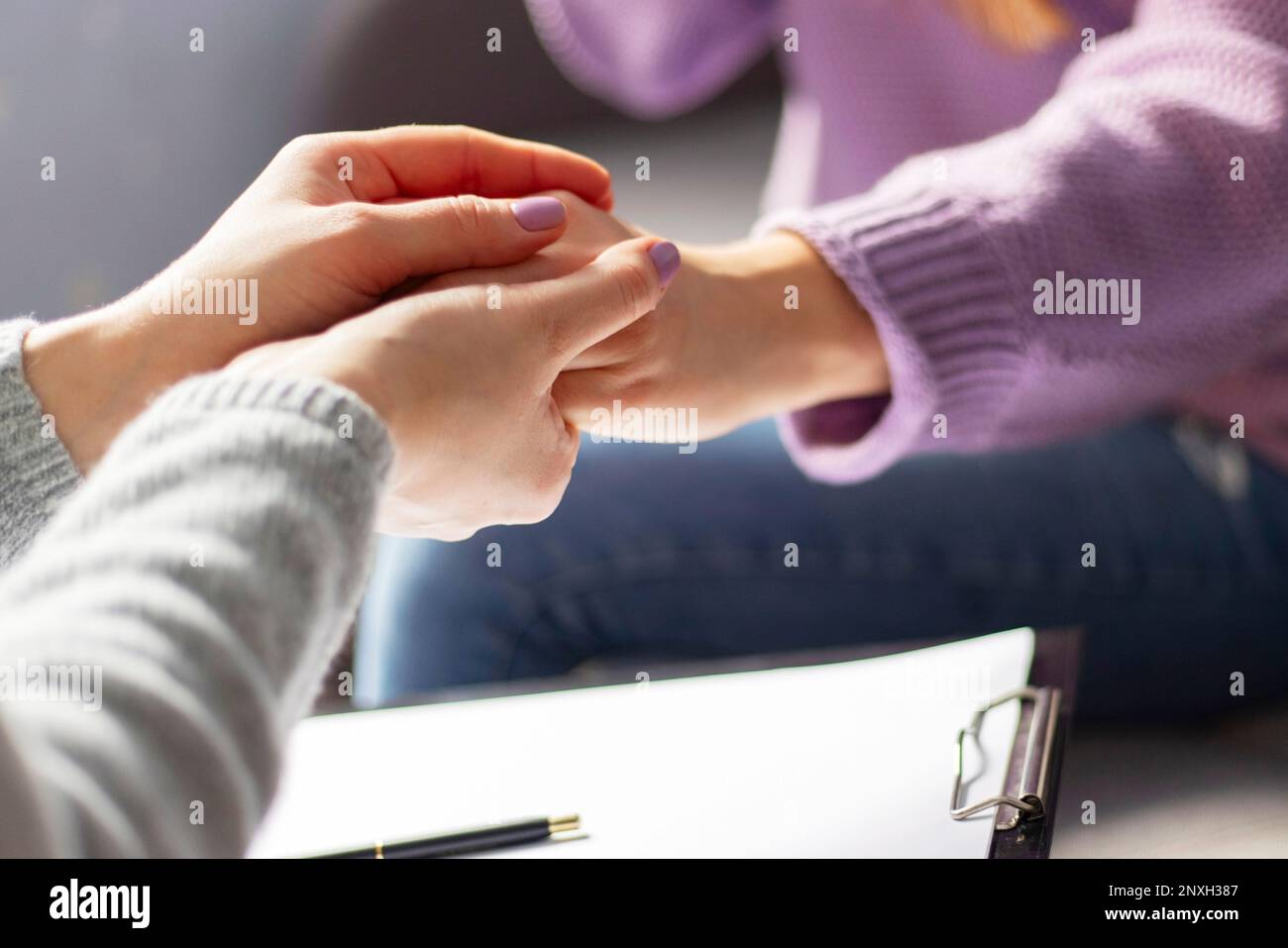 Close therapist holding clipboard, touching patients hands Stock Photo ...