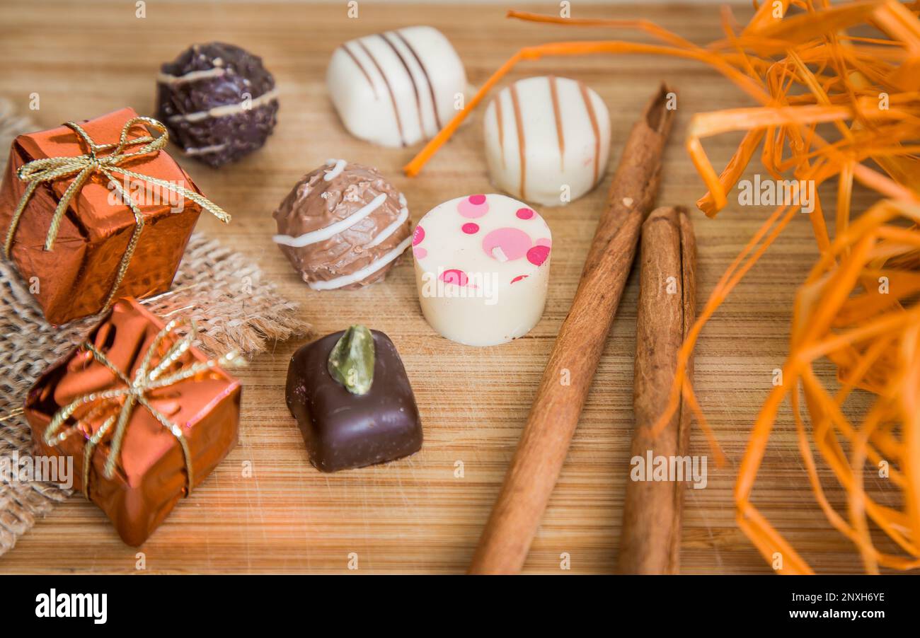 Chocolate pralines with small package decoration in orange color and ...