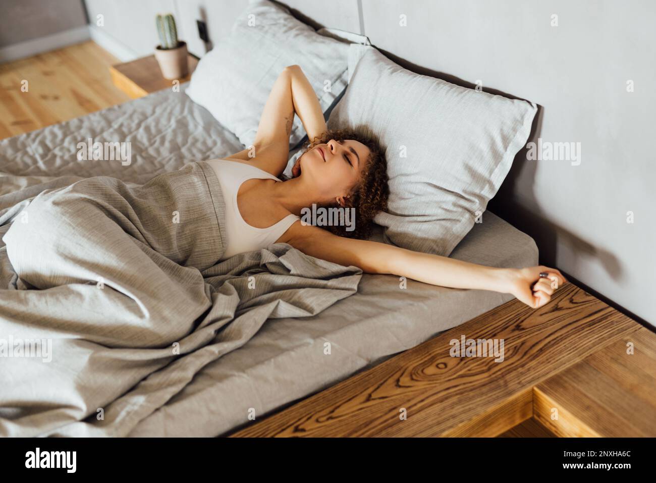 Happy girl waking up stretching arms on the bed in the morning Stock ...