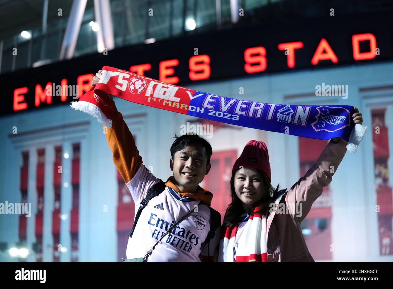 Arsenal fans pose for pictures with a match half and half scarf outside ...