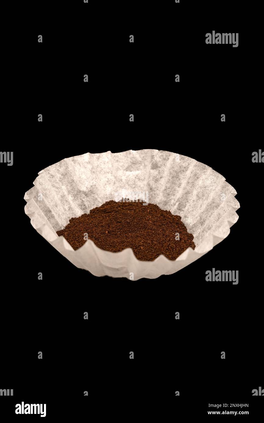 Coffee grounds in a white coffee filter on black background Stock Photo ...