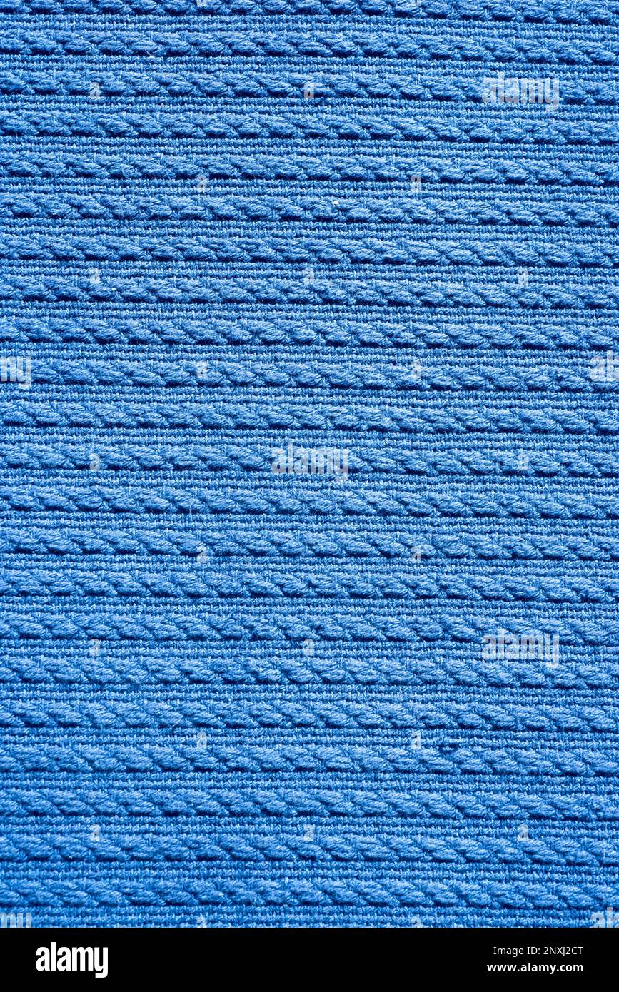 Vertical full-frame background image with a blue fabric with decorative ...