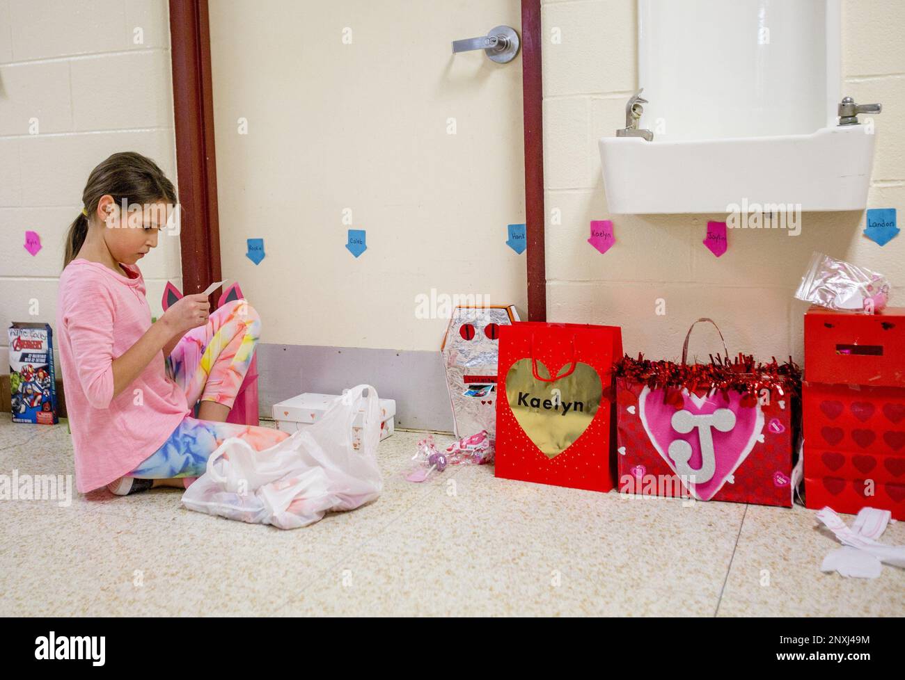 Second-grader Sophia Hill, 8, reads a Valentine's Day card she received ...