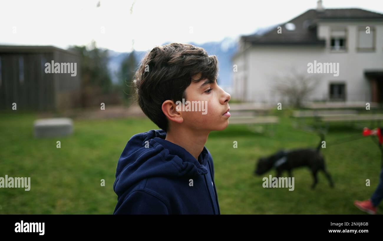 Thoughtful handsome teen young boy walking forward at park. Tracking ...