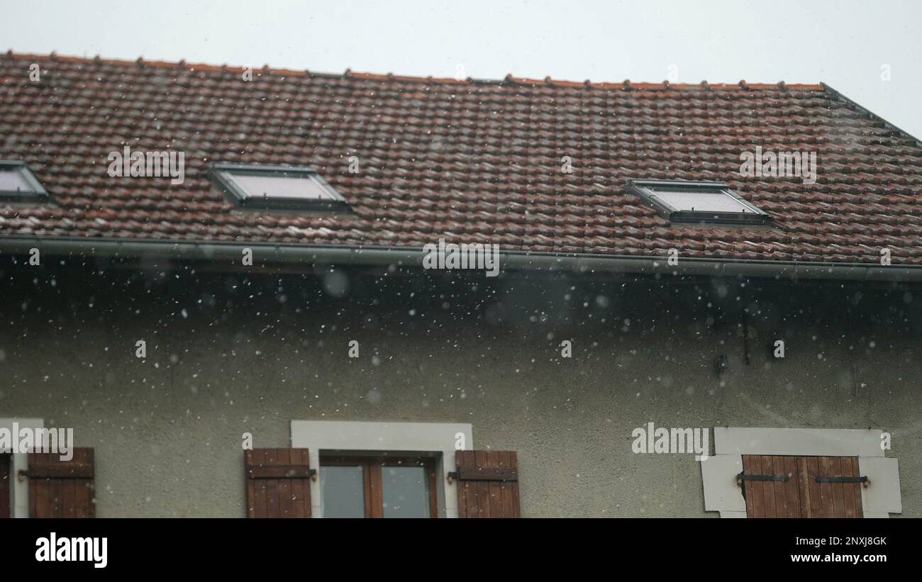 Winter season snow falling on building rooftop. Traditional ...