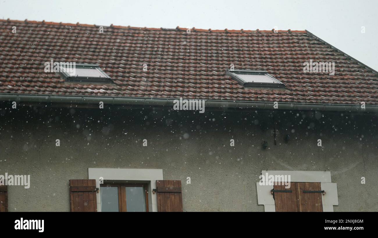 Winter season snow falling on building rooftop. Traditional ...