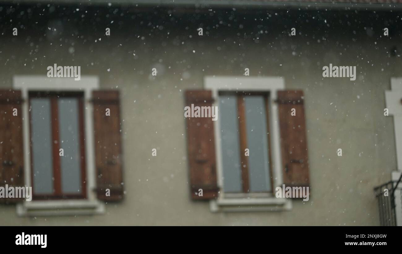 Winter season snow falling on building rooftop. Traditional ...