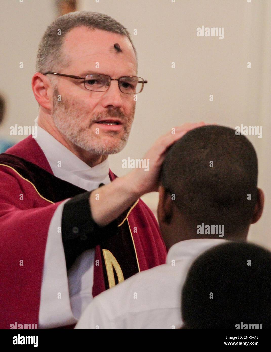 Father Matthew Simmons, of St. Patrick Catholic Church, marks the ...