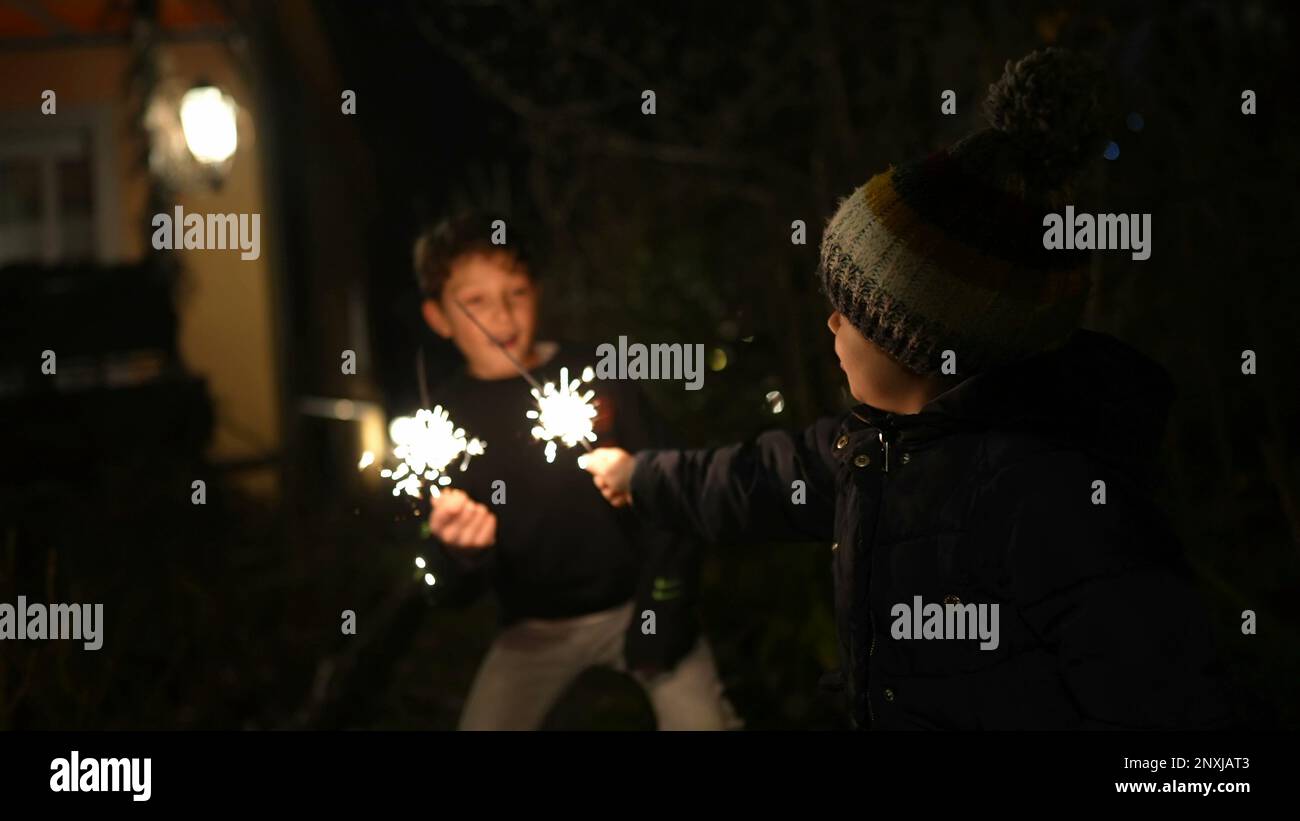 Happy children holding sparkler during holidays. Kids celebrating event ...