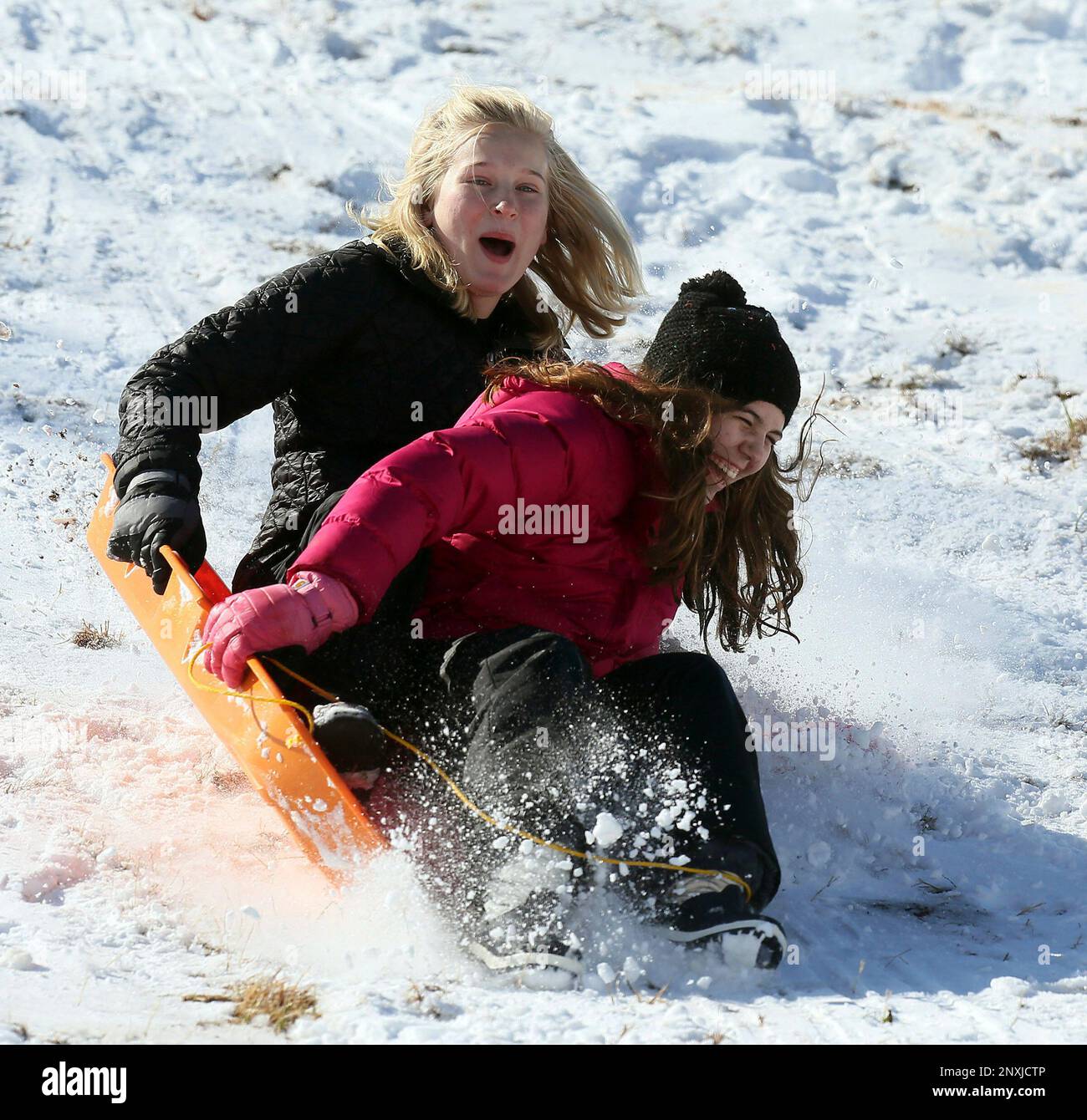 Haley McCall, 16, left, and Jenna Allen, 16, lose control of their sled ...