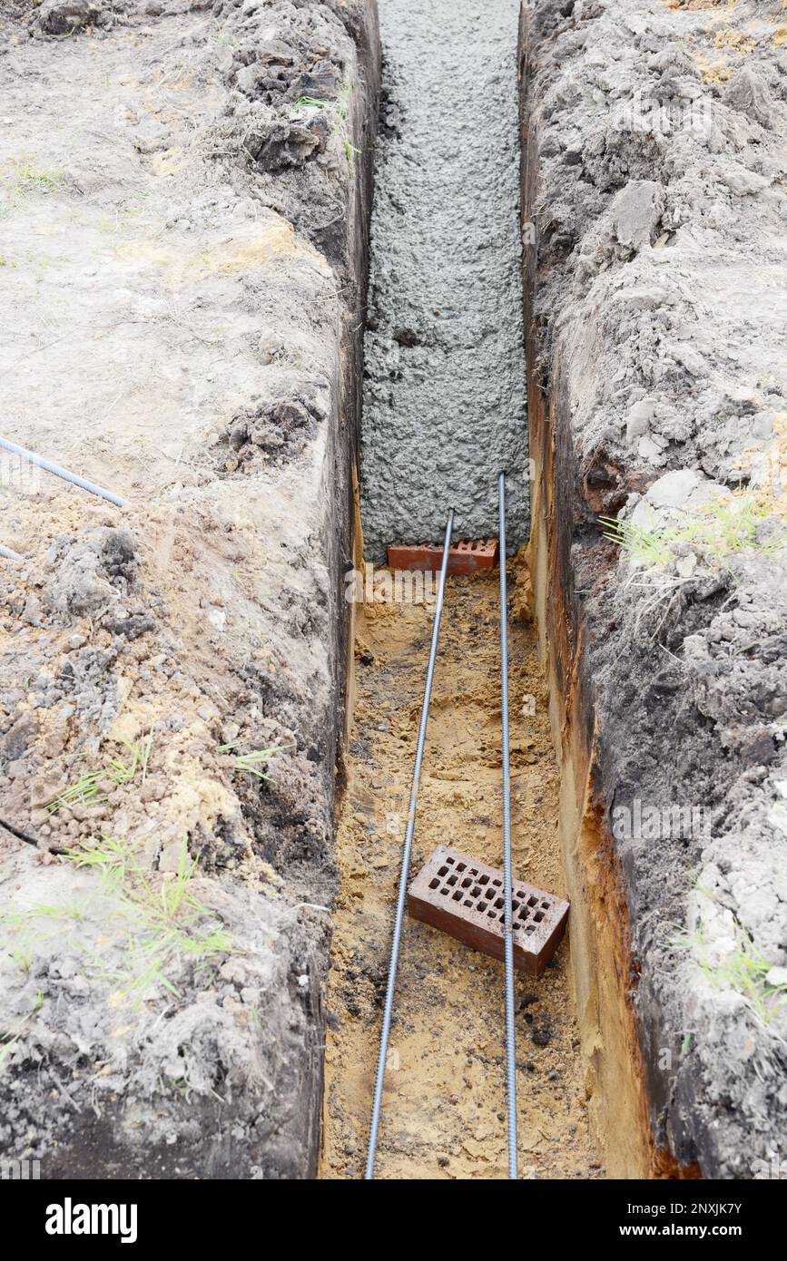 Filling strip foundation with concrete at the construction site. start ...